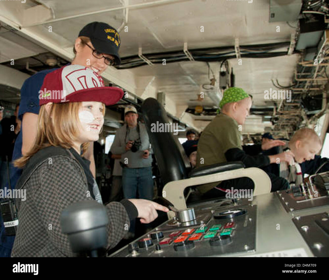 Ensign Anna Mueller shows 7-year-old Luke O'Moore how to steer Stock ...