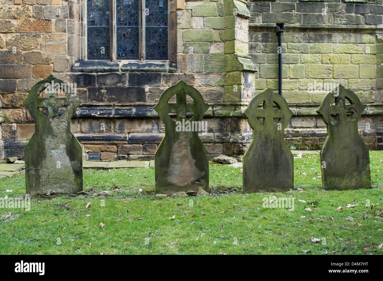 Like four people standing in a line, four old weathered gravestones ...