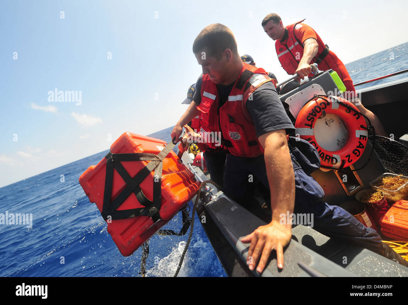 The U.S. Coast Guard boat crew retrieves an airdropped part from a 295 ...