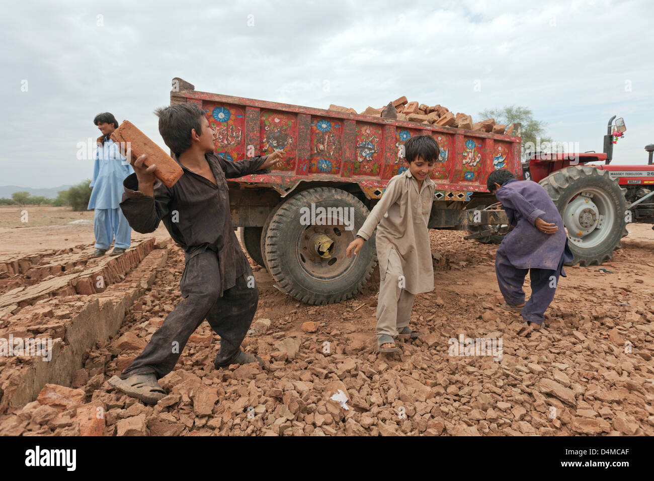 Islamabad, Pakistan, children throwing bricks on a tractor Stock Photo ...