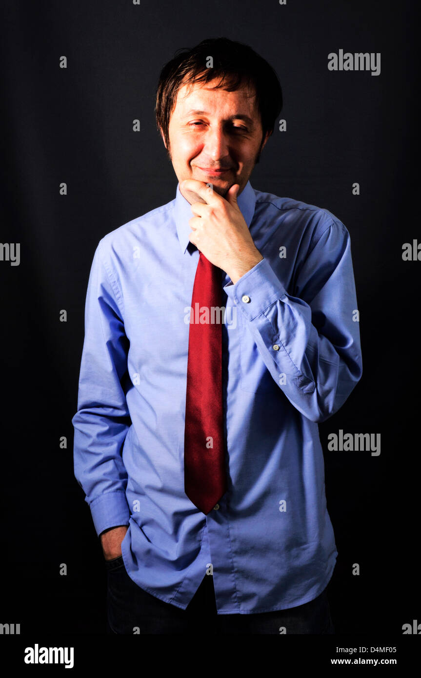 Male with greedy smile on dark background Stock Photo - Alamy