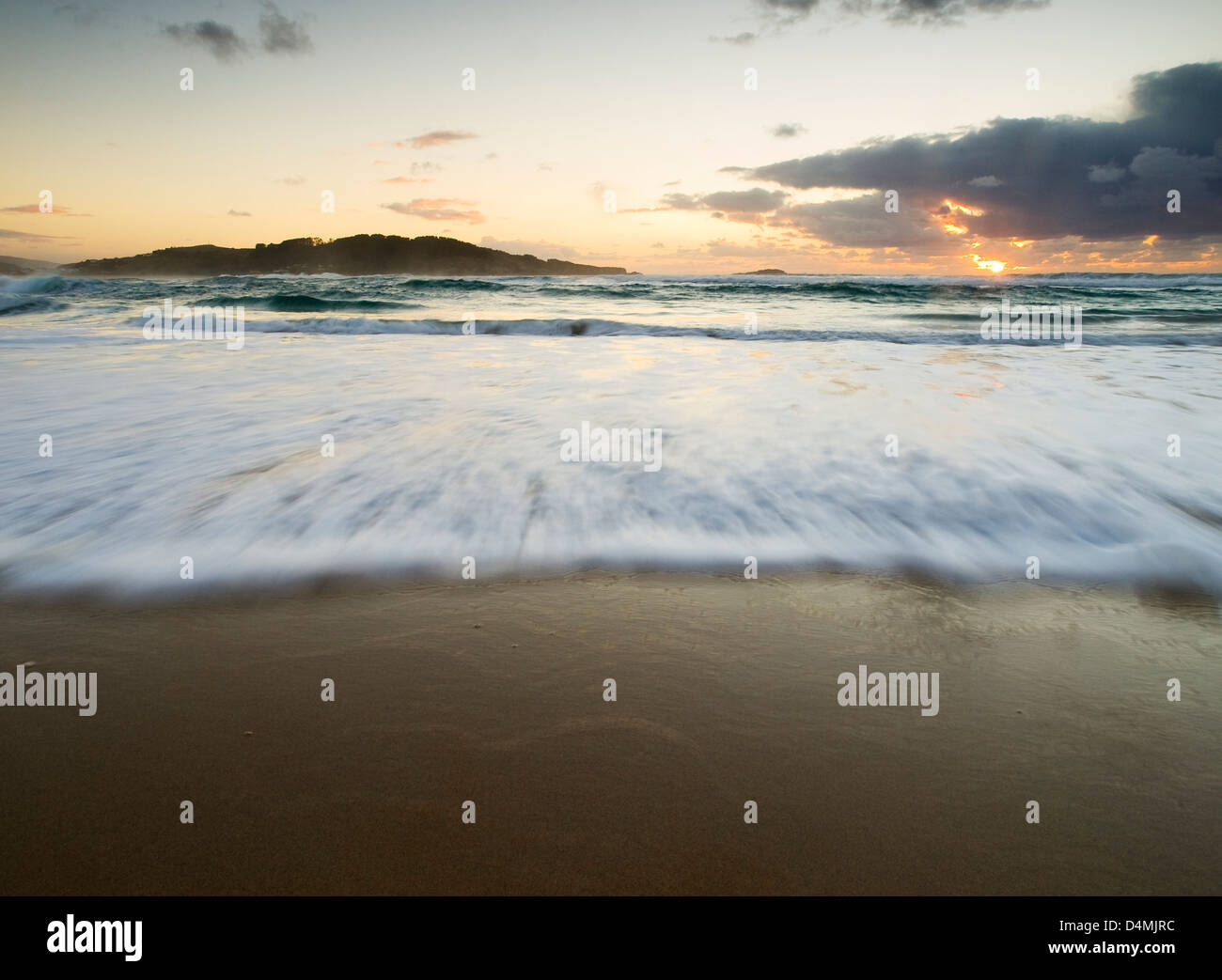 Wave on the beach in a sunset Stock Photo - Alamy