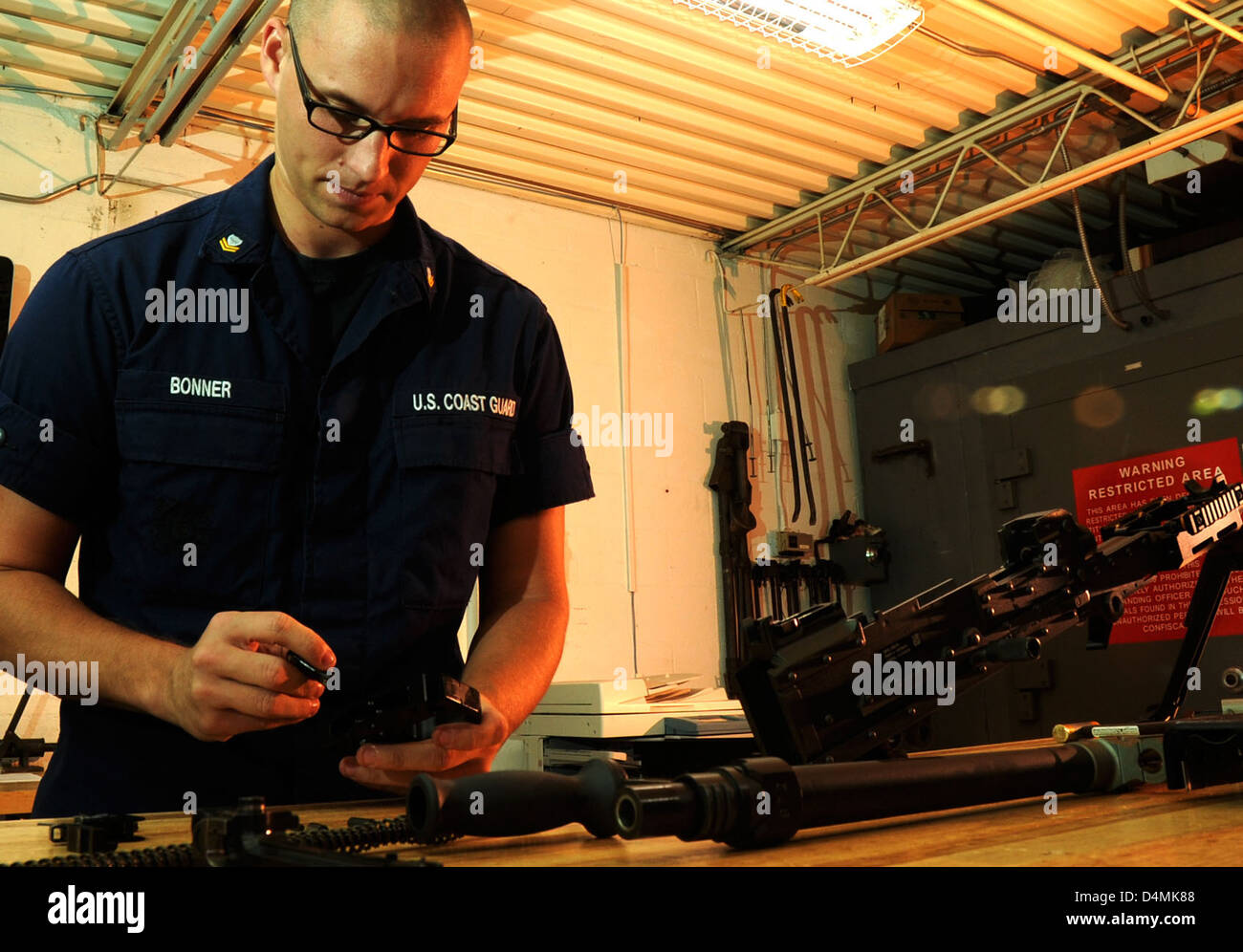 U.S. Coast Guard Gunner's Mate (GM) Seth Johnson performs maintenance ...