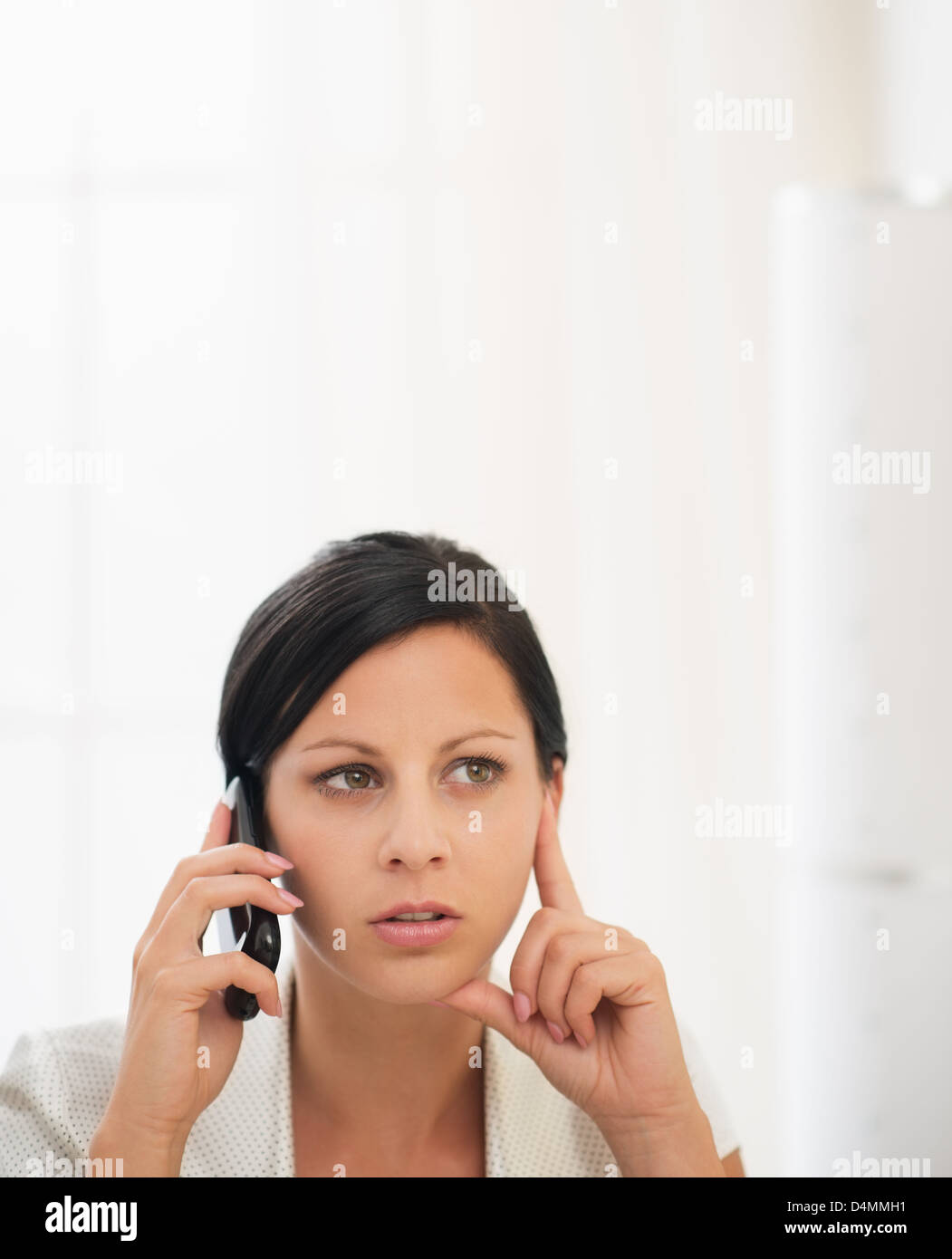 Concerned young woman talking mobile phone Stock Photo - Alamy