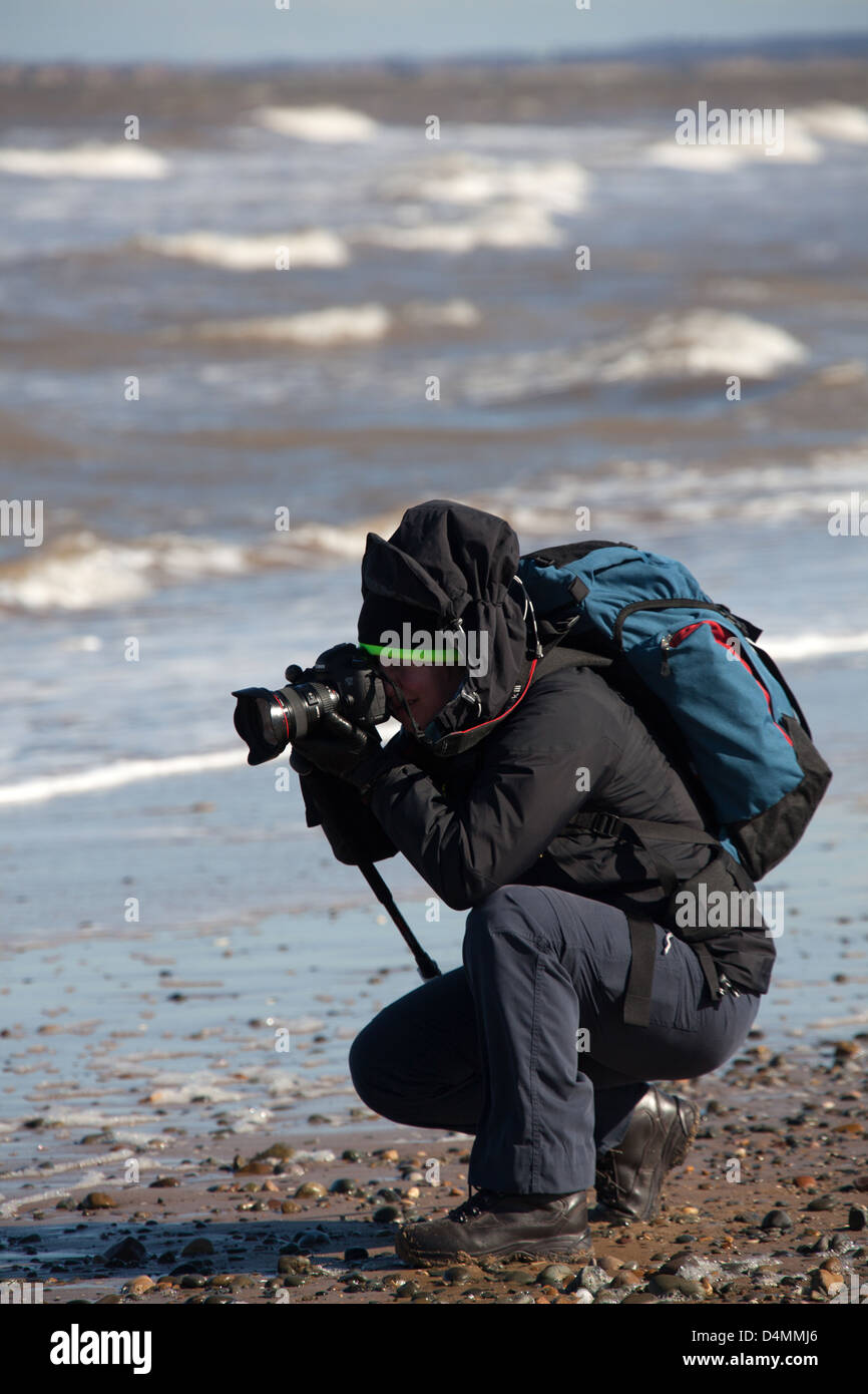 The Wales Coastal Path in North Wales. Photographer wrapped up against ...