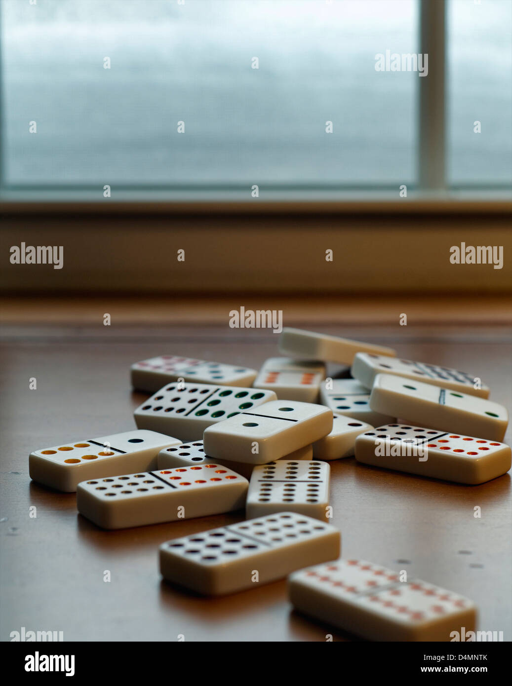 A scattered stack of dominos laying on table in front of snow covered ...