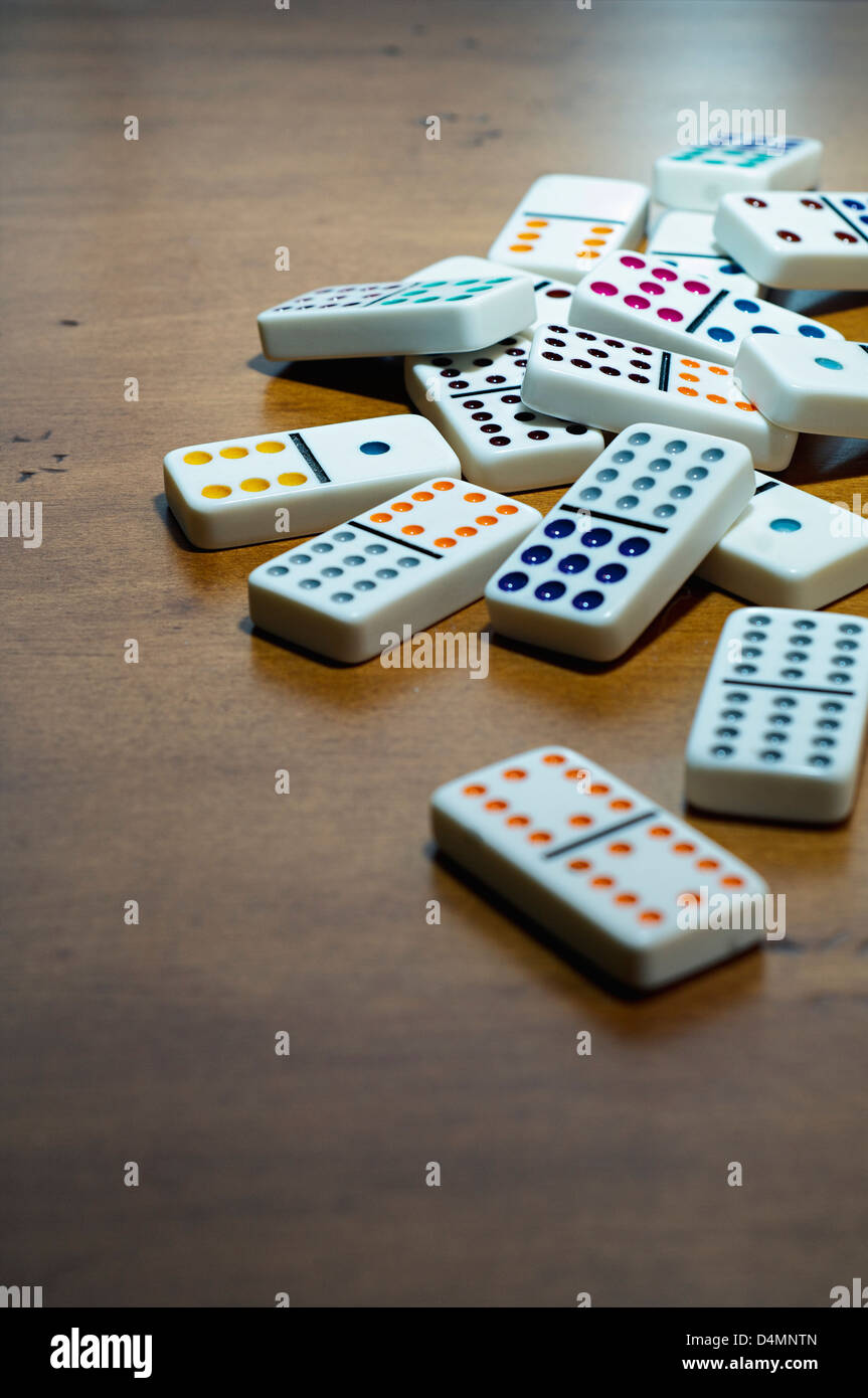 A scattered stack of dominos laying on wooden table Stock Photo - Alamy