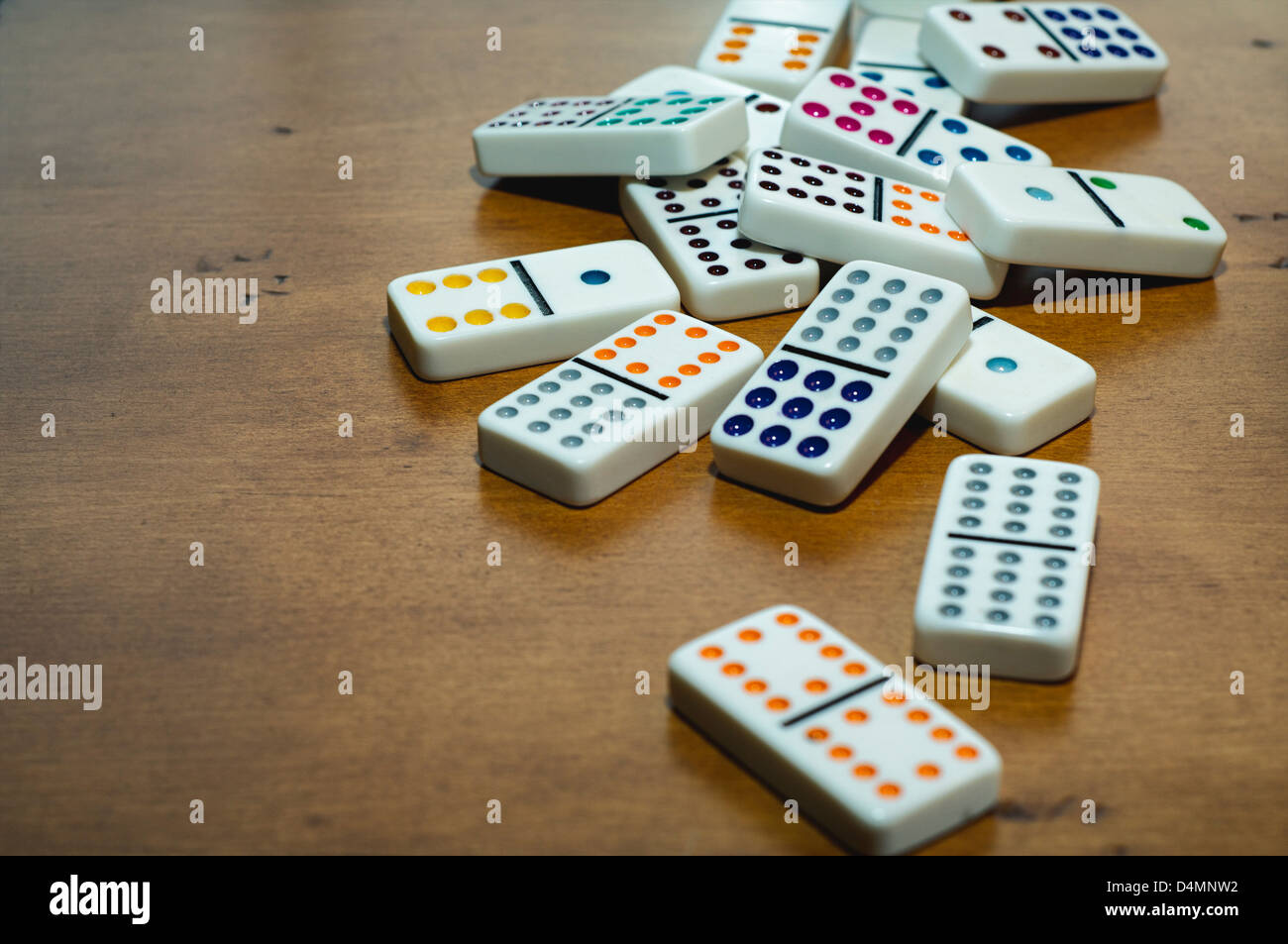 A scattered stack of domino's laying on wooden table Stock Photo - Alamy