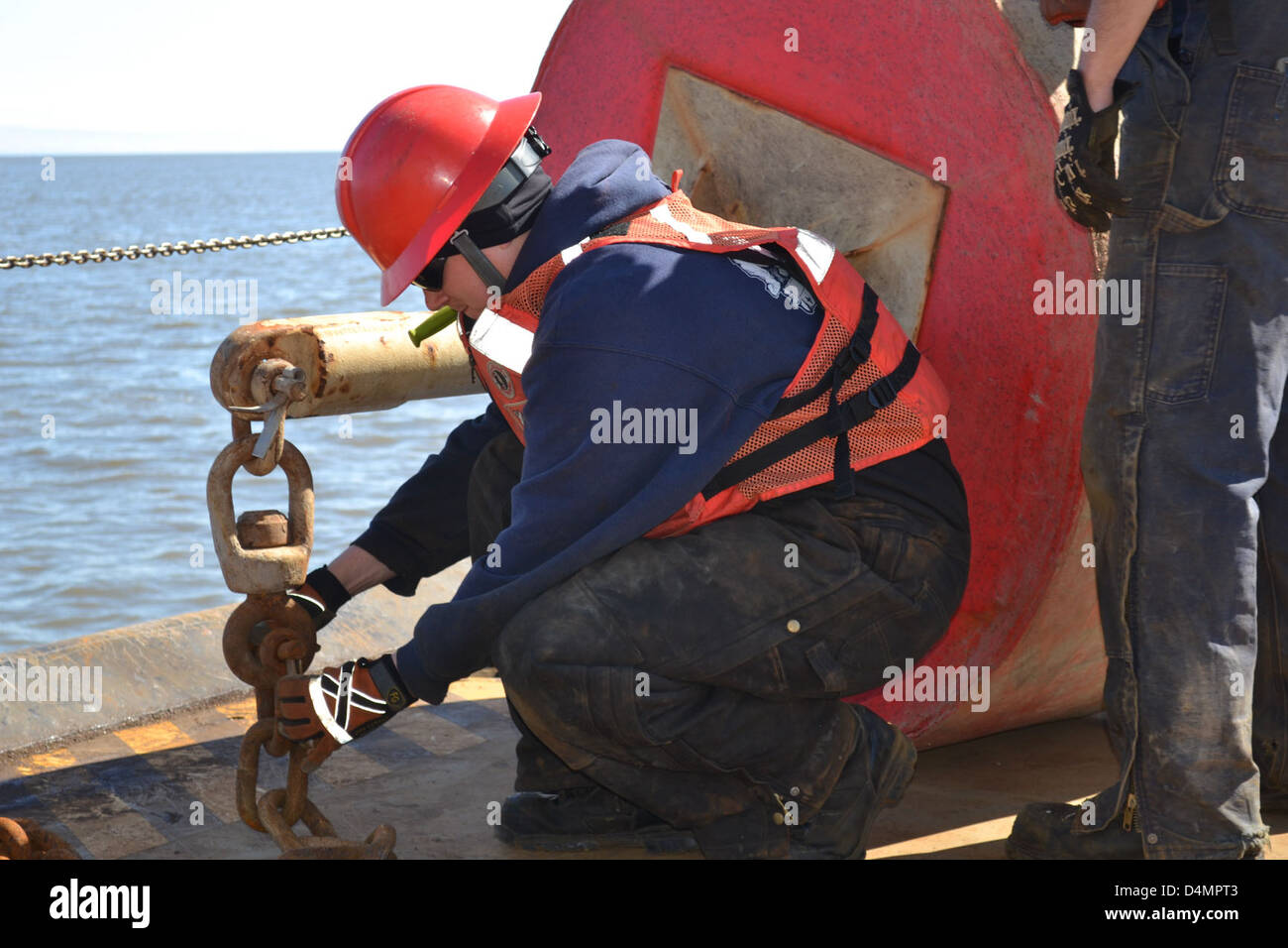 Petty Officer 2nd Class George Atkins, a Damage Controlman, attaches a ...