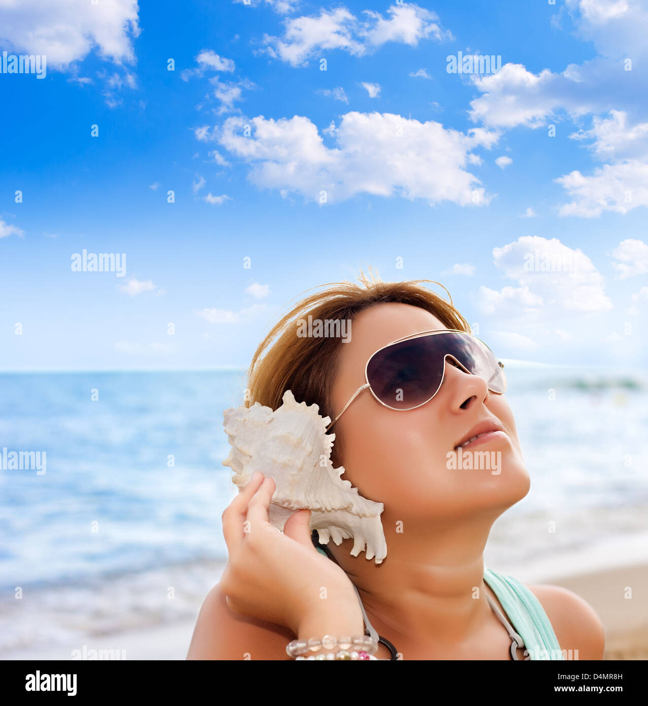 Woman holding conch shell ear hi-res stock photography and images - Alamy