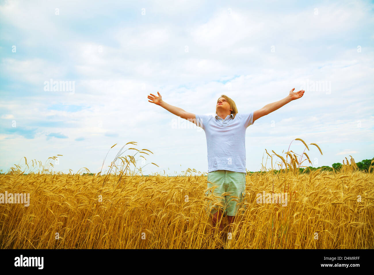 Young man staying with raised hands at sunset time Stock Photo - Alamy