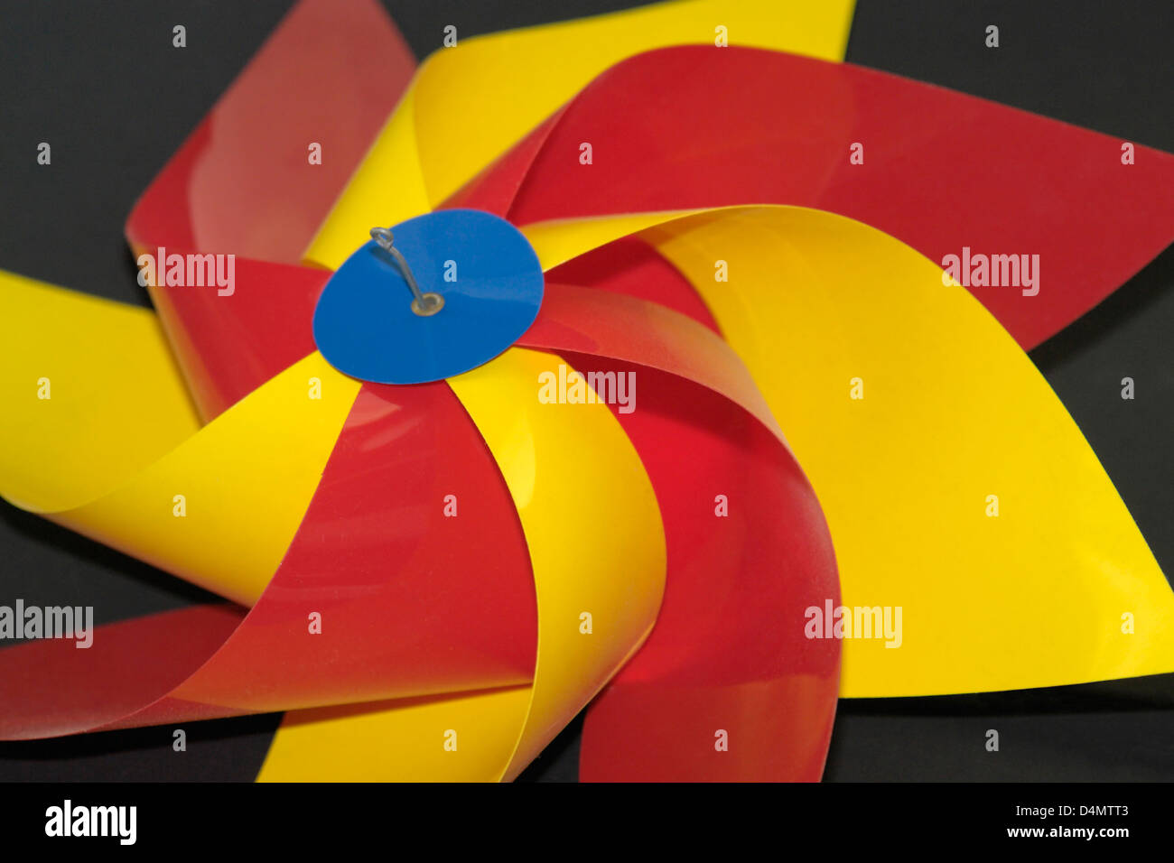 studio photography showing the detail of a colorful wind wheel in black ...