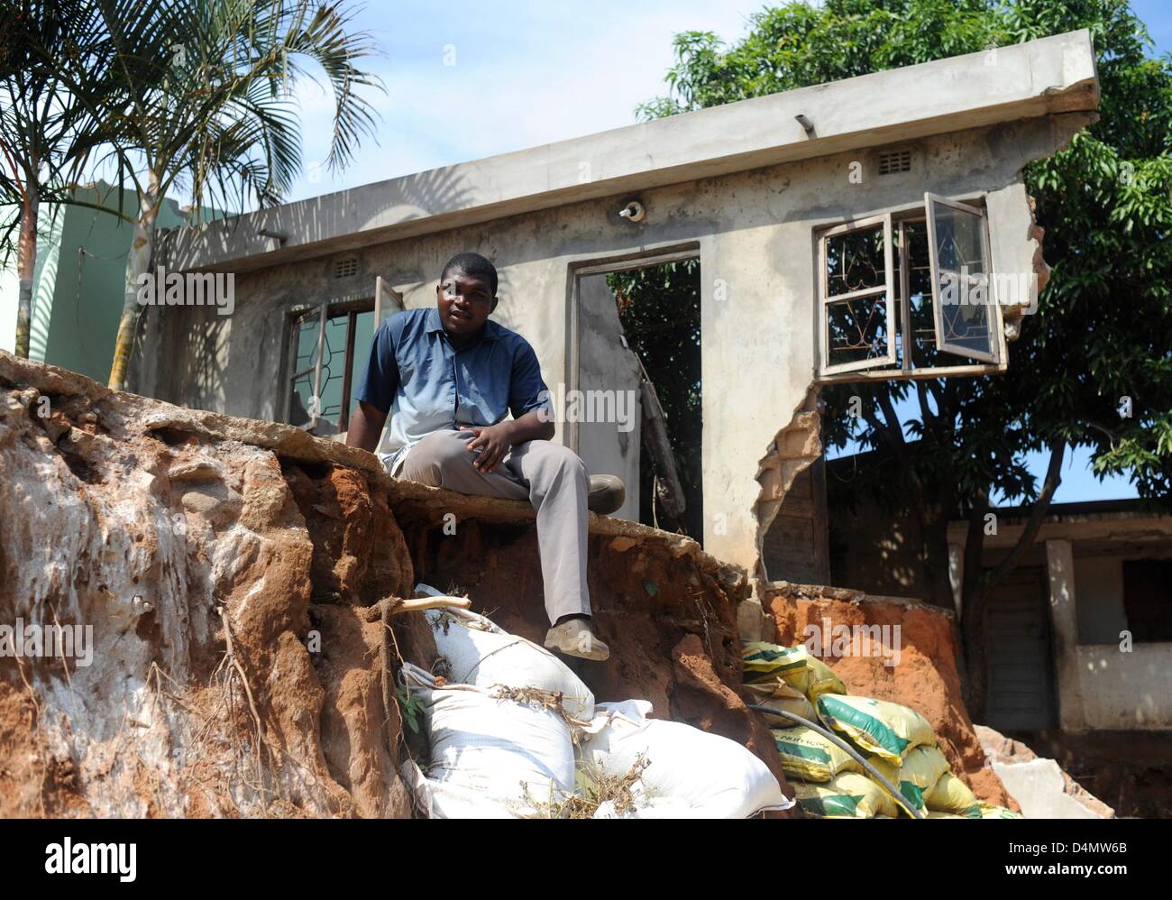 Nelson Carlos sits in front of his destroyed house in Bairro de Laulane ...