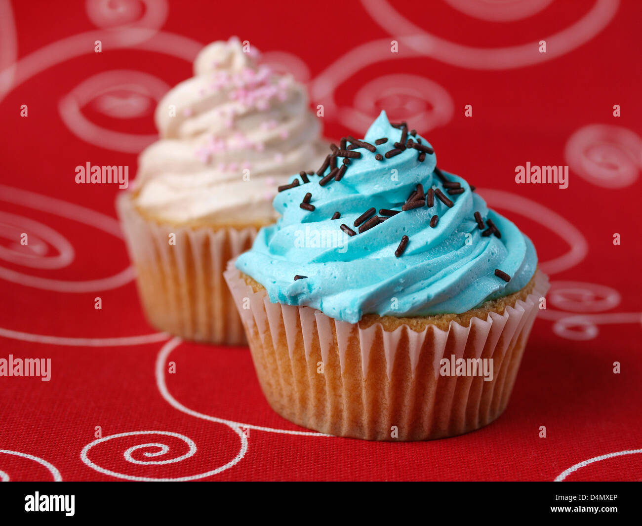 Two different colored cupcakes. A cupcake is in focus and the other isn ...