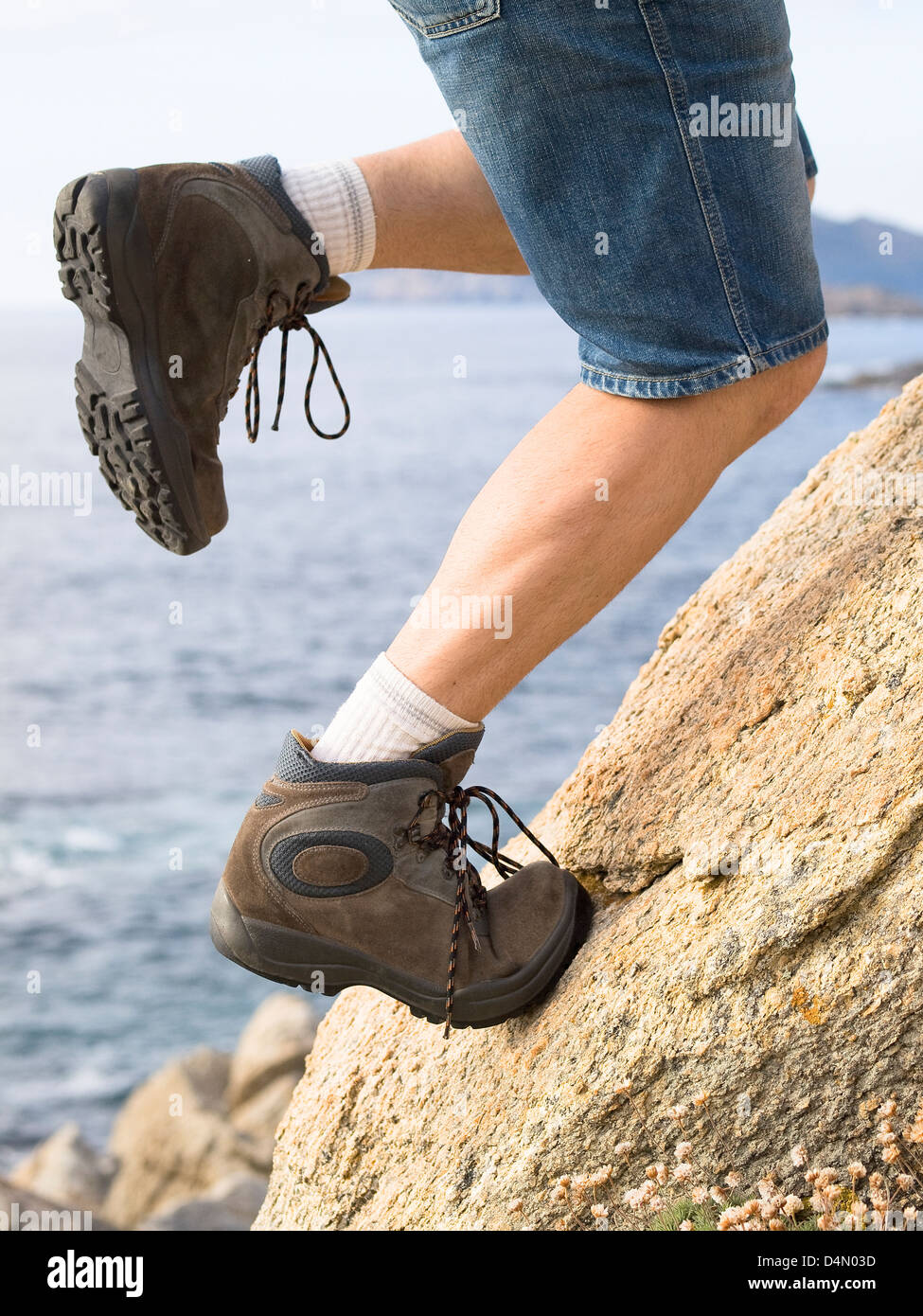 Man climbing a rock. The photo shows a man's legs while climbing a rock ...