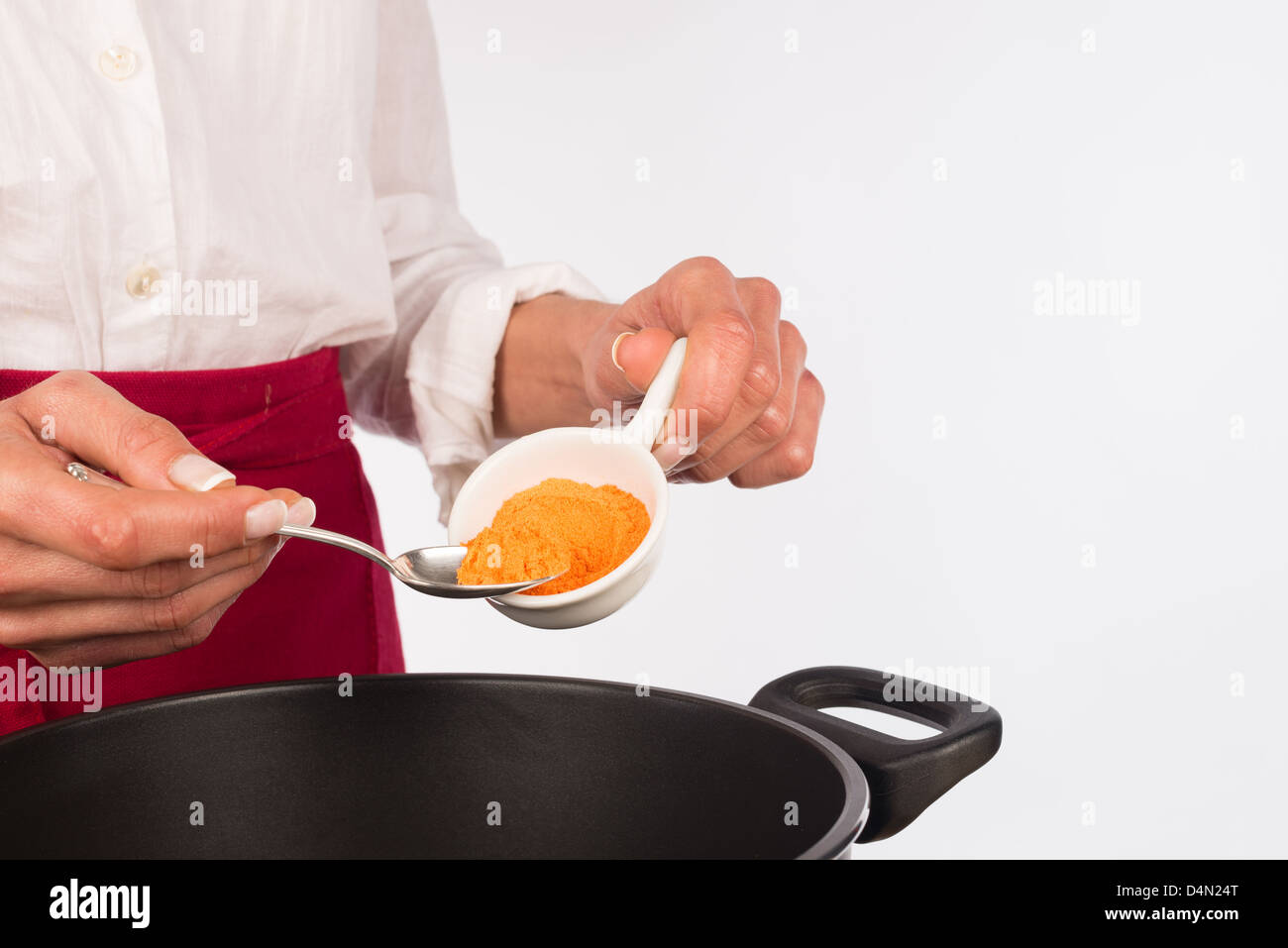Female hands adding curry powder to a pot Stock Photo - Alamy
