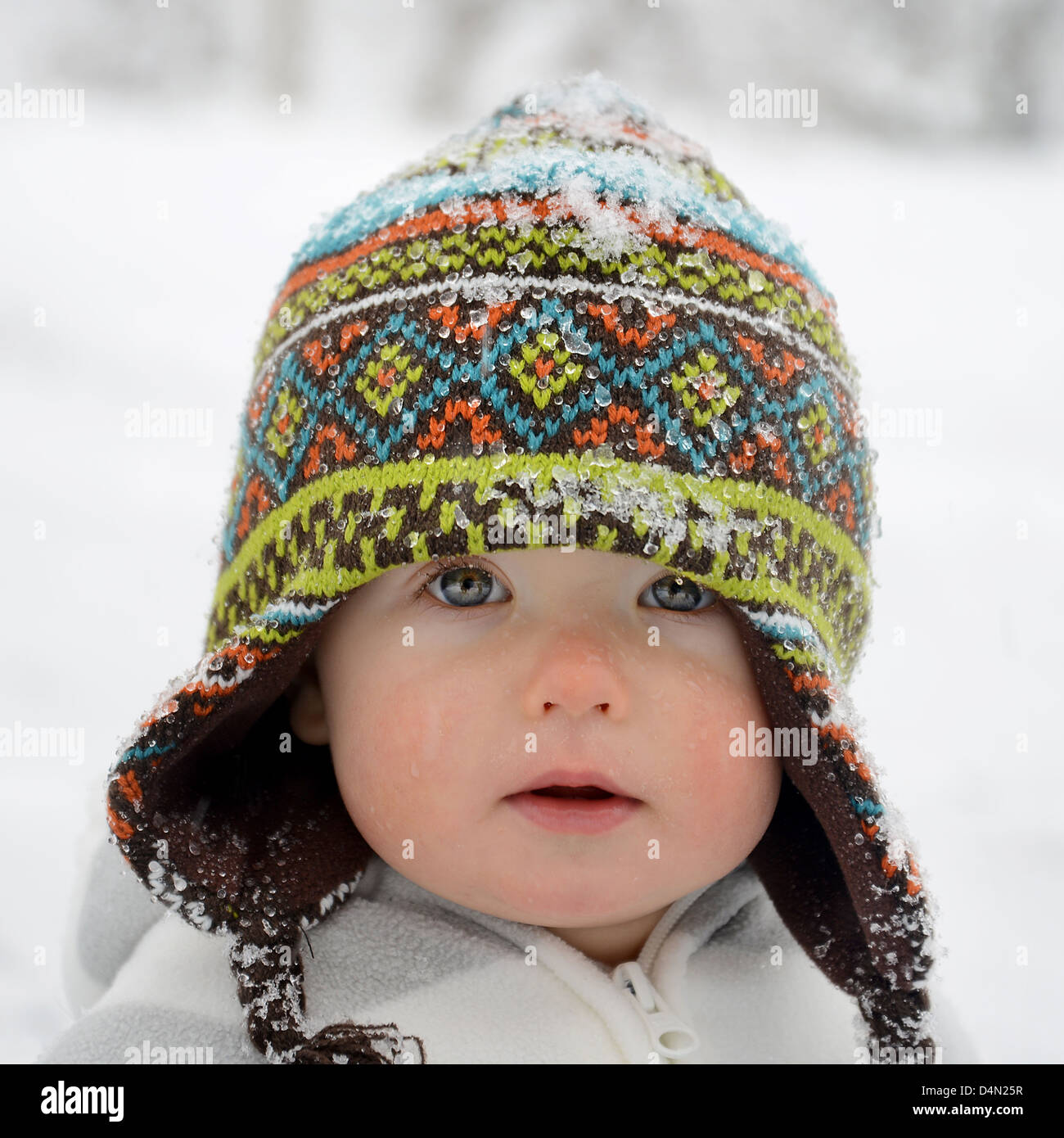 Baby in hat enjoying the winter snow while sledding Stock Photo - Alamy