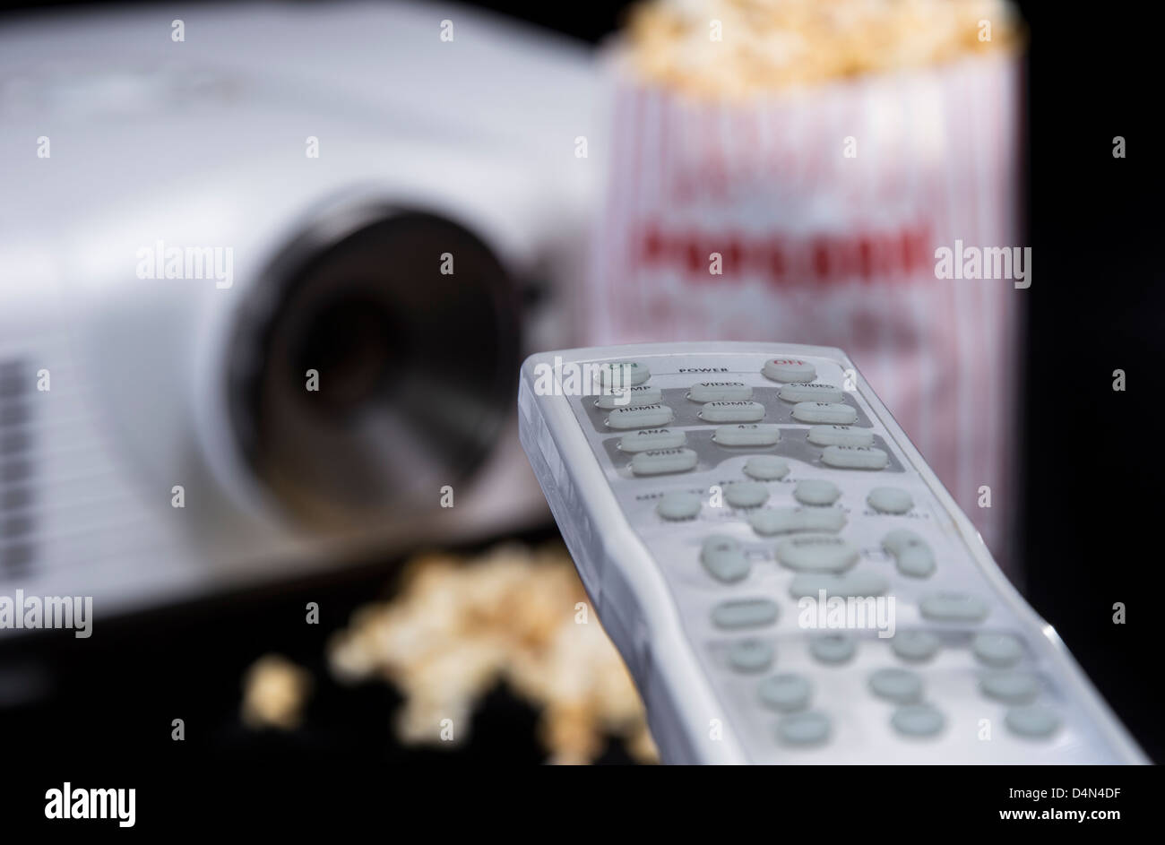 Remote Control with Beamer and Popcorn in the background Stock Photo ...