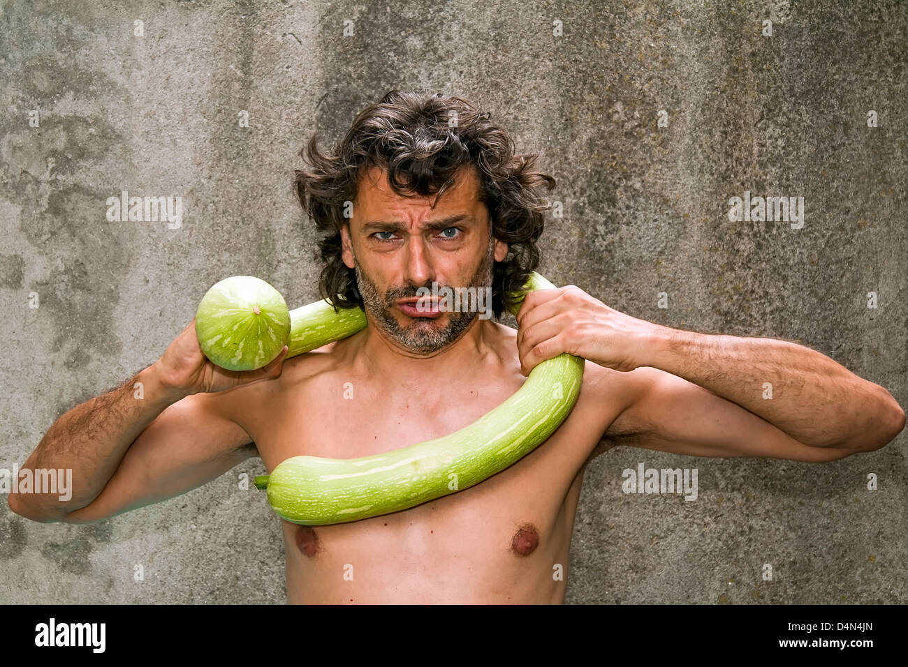 man have a funny fight with a big zucchini squash Stock Photo - Alamy
