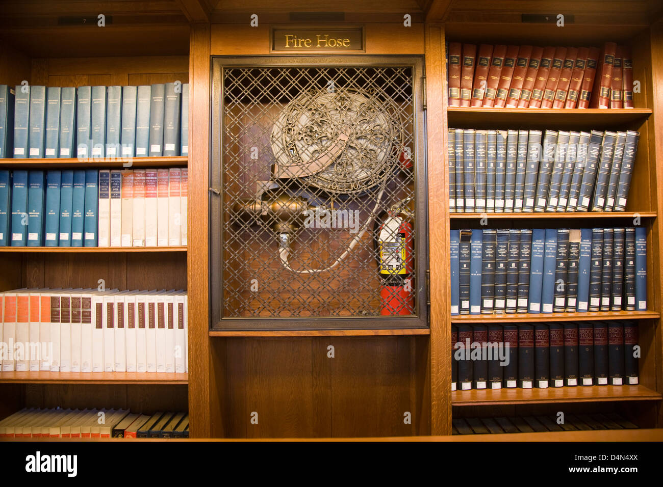 Old fashioned fire hose and extinguisher surrounded by books in the New ...