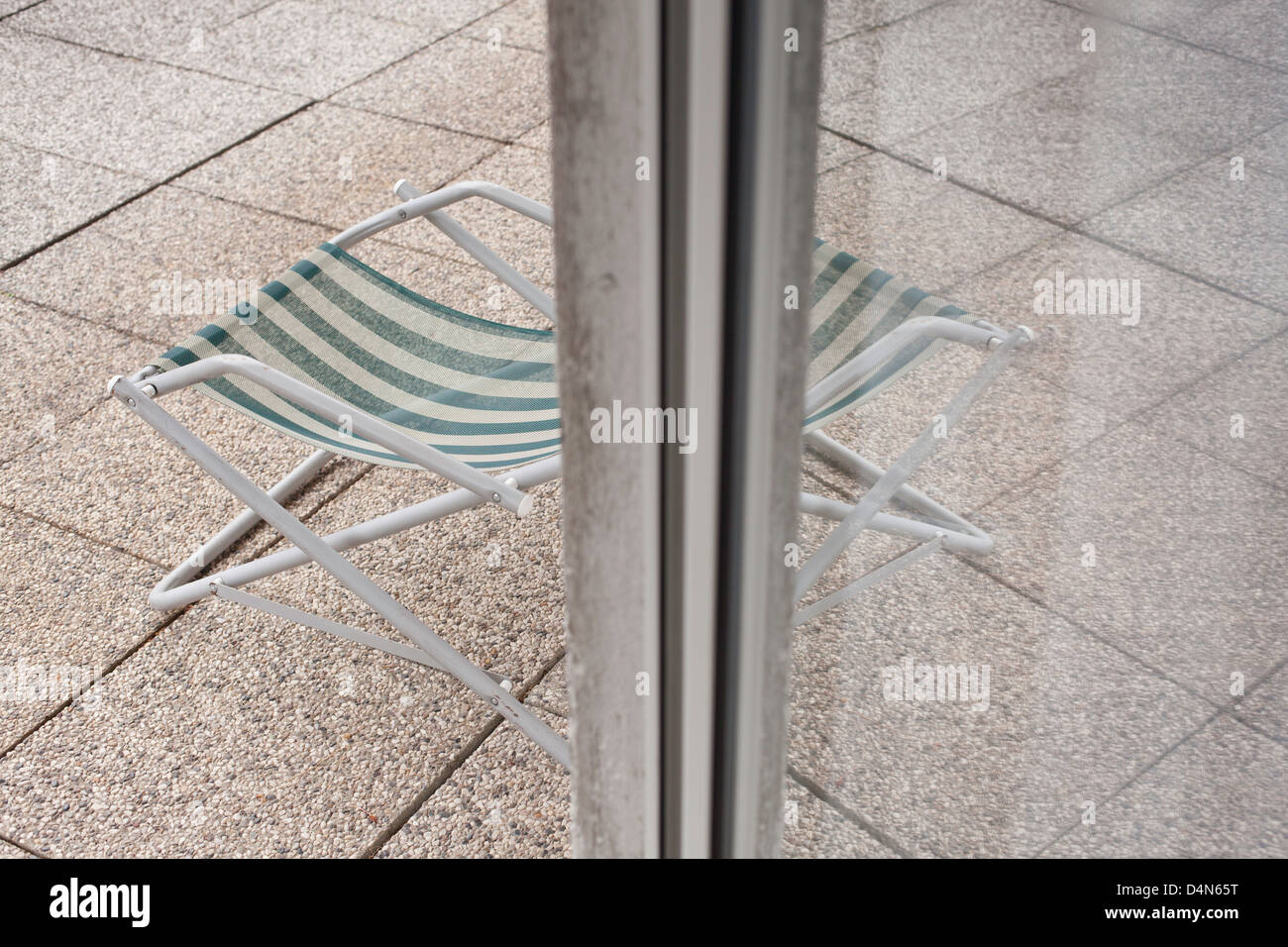 beach chair on a balcony distorted by a mirror creating optical ...