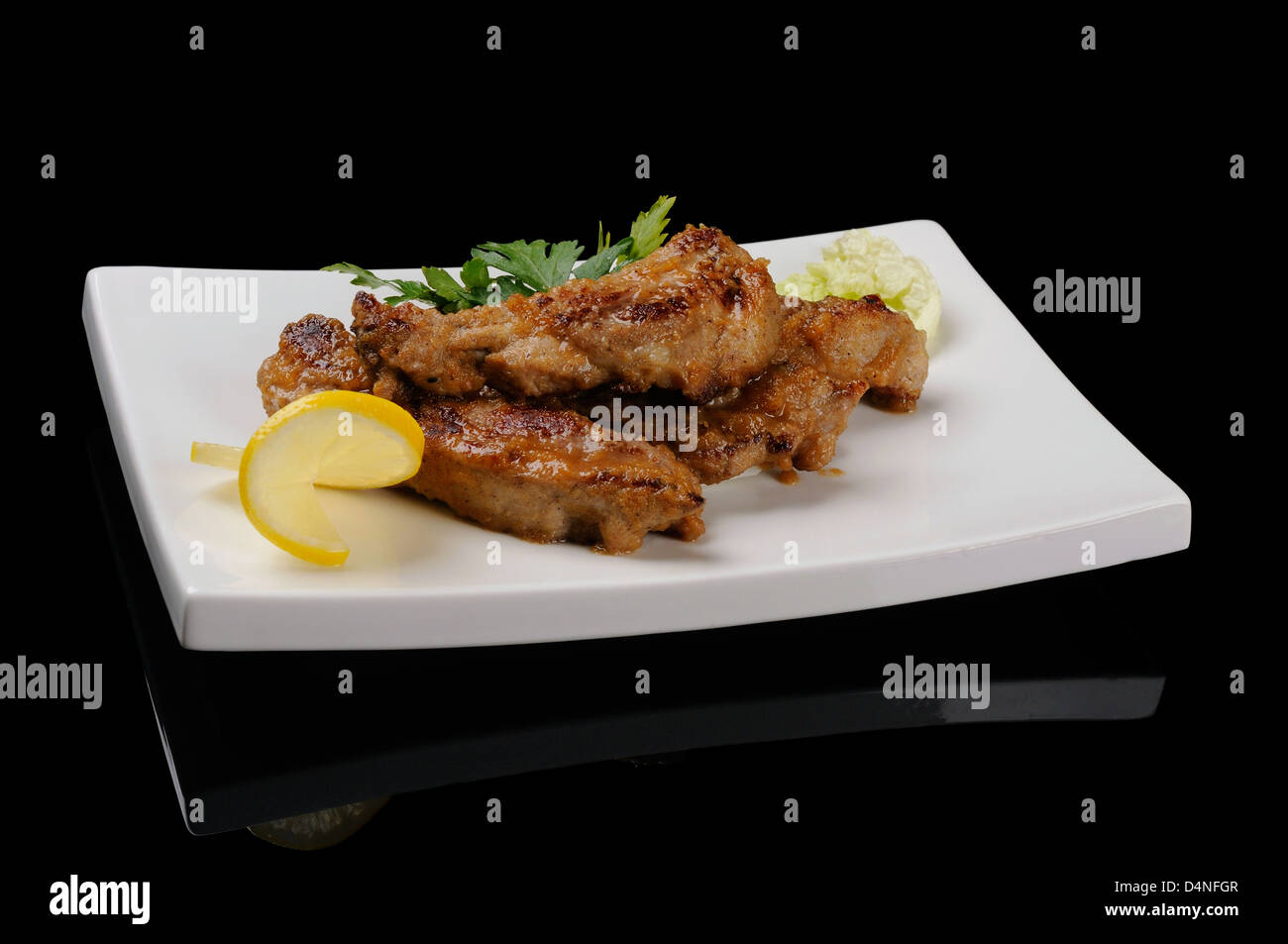 Fried pork ribs on white plate over black background Stock Photo - Alamy