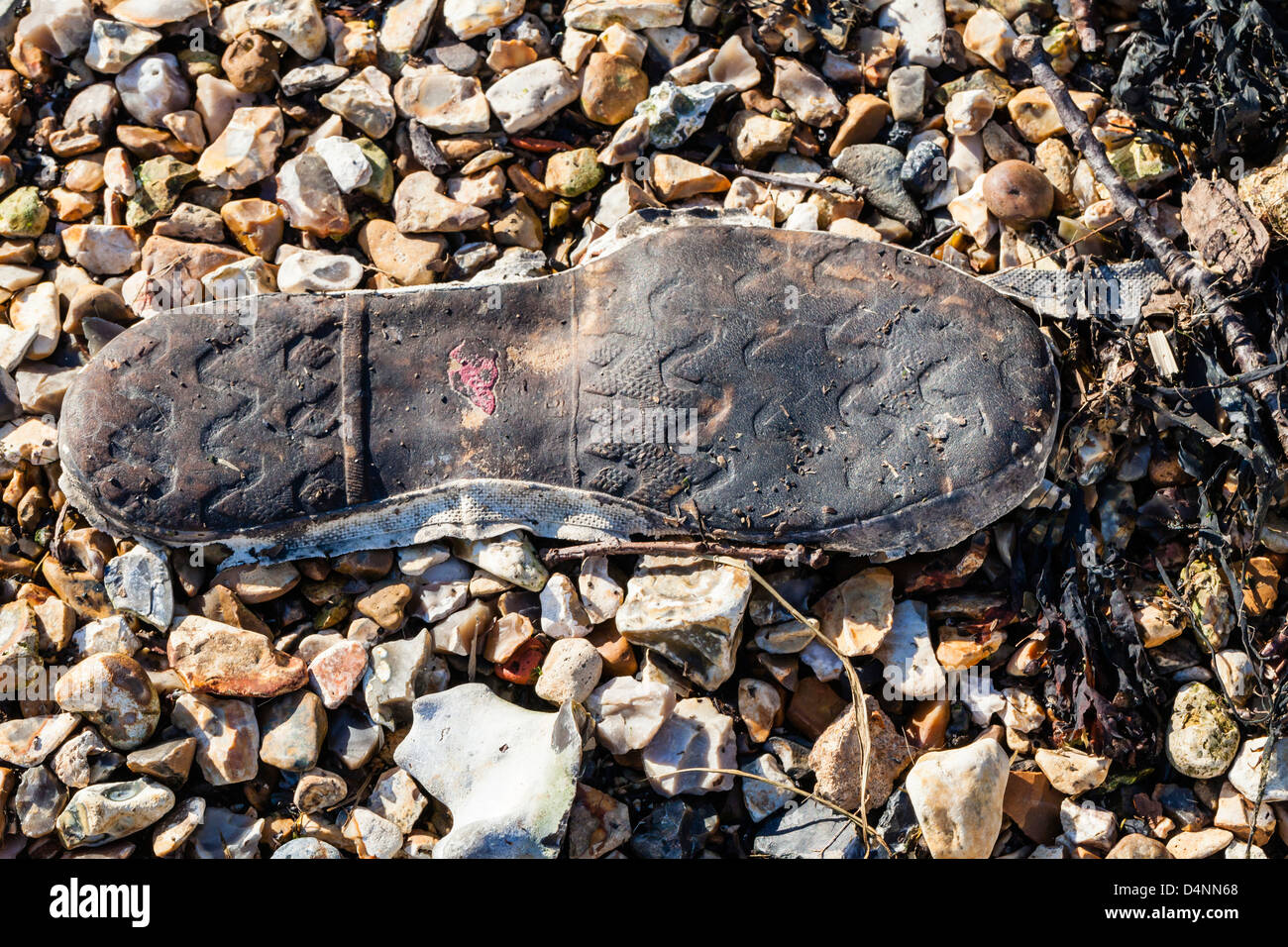 Worn out shoe on the pebble beach at Dell Quay near Chichester, West ...
