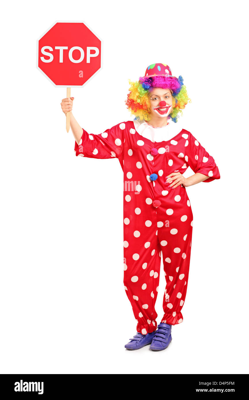 Full length portrait of a clown holding a stop sign isolated against ...