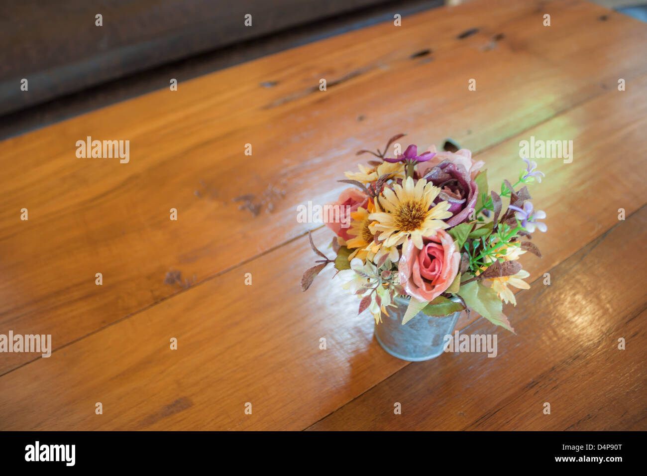 Beautiful colors of plastic flowers on wood table Stock Photo - Alamy