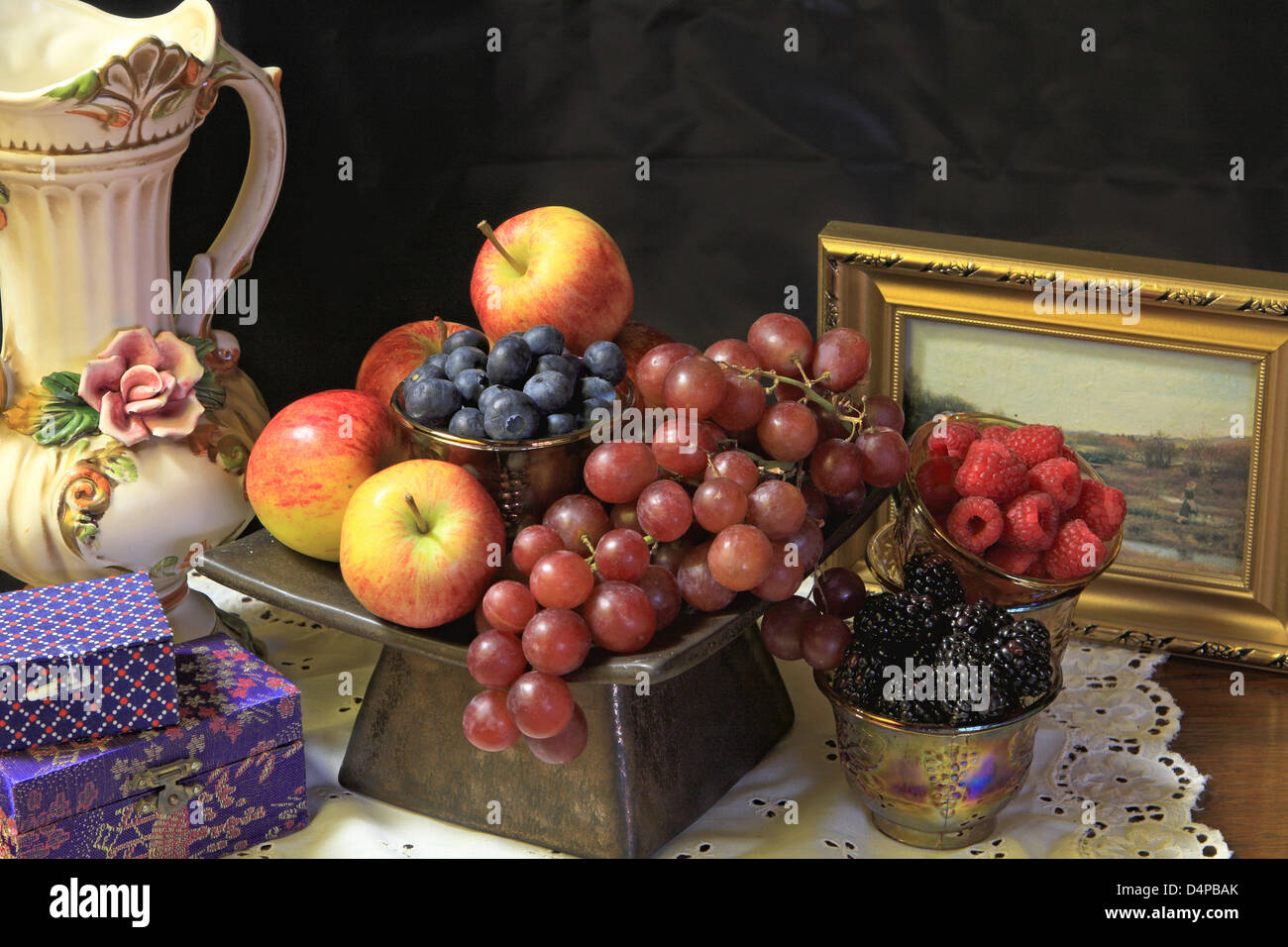 A still life photo of fruit and berries with accompanying vase and ...