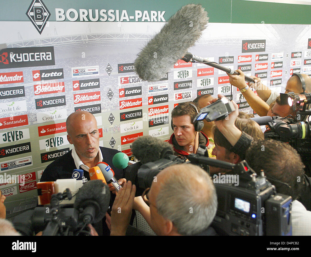 Soccer coach Michael Frontzeck (L) is surrounded by media during a ...