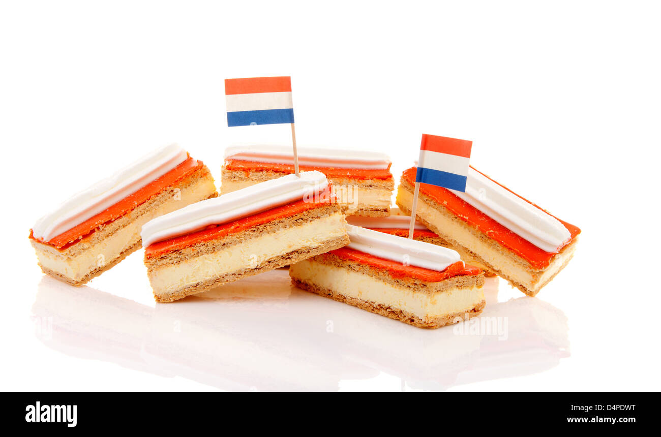 Pile of traditional Dutch pastry called tompouce with flags over white ...