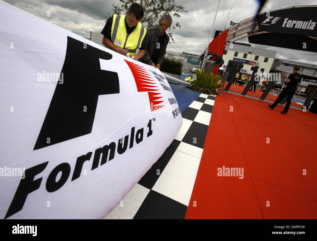Workers prepare a F1 flag at the Silverstone race track in ...