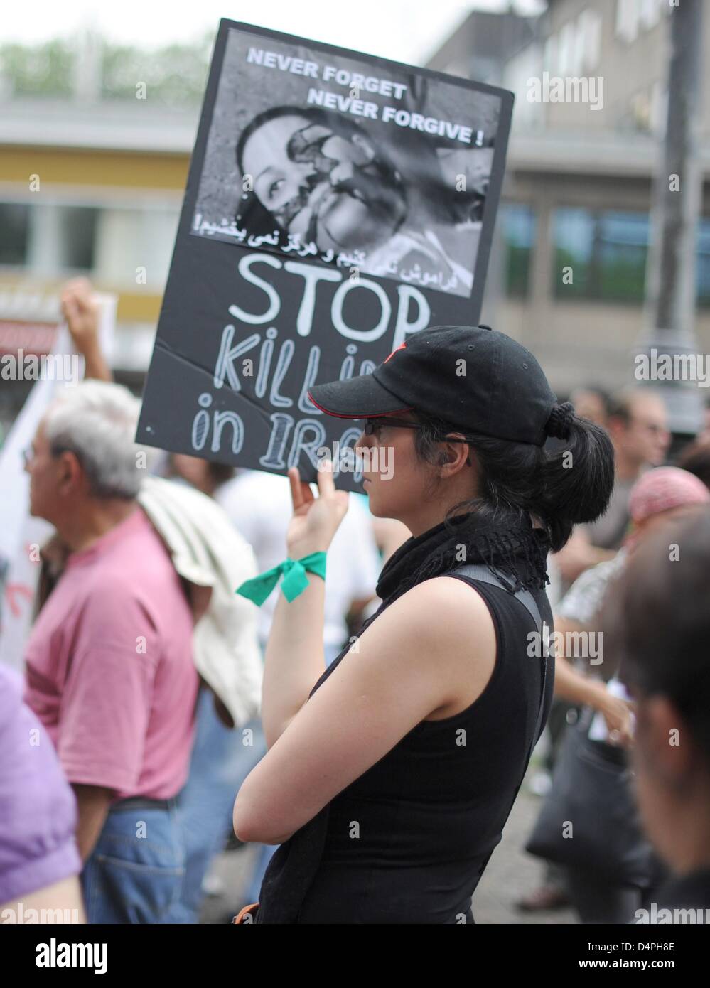 A protester holds up a banner with the picture of student Neda Agha ...