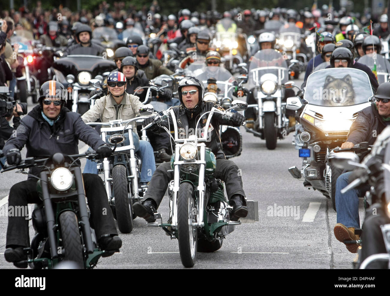 Participants of the motorcycle parade pass spectators during the ...