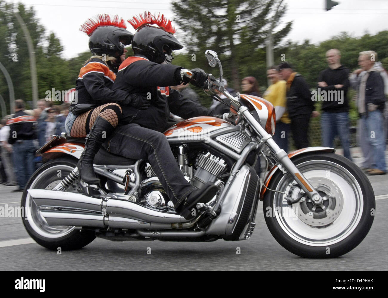 Two participants of the motorcycle parade pass spectators during the ...