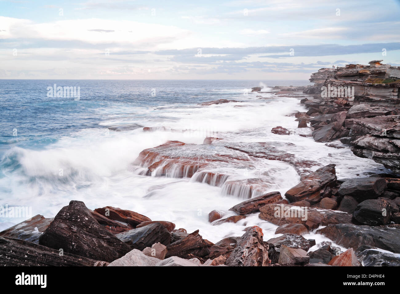 Sea shoreline with rocks and people far away Stock Photo - Alamy