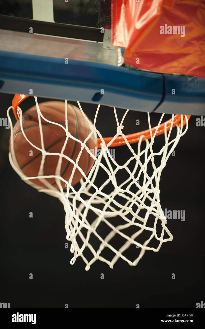 Basketball going through hoop Stock Photo - Alamy