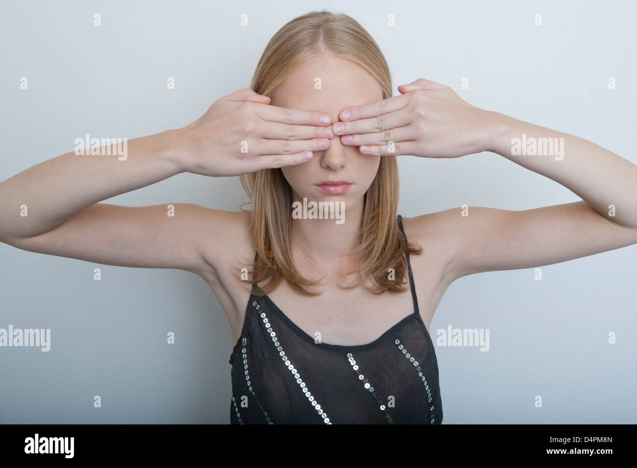 Young woman with hands covering eyes Stock Photo - Alamy
