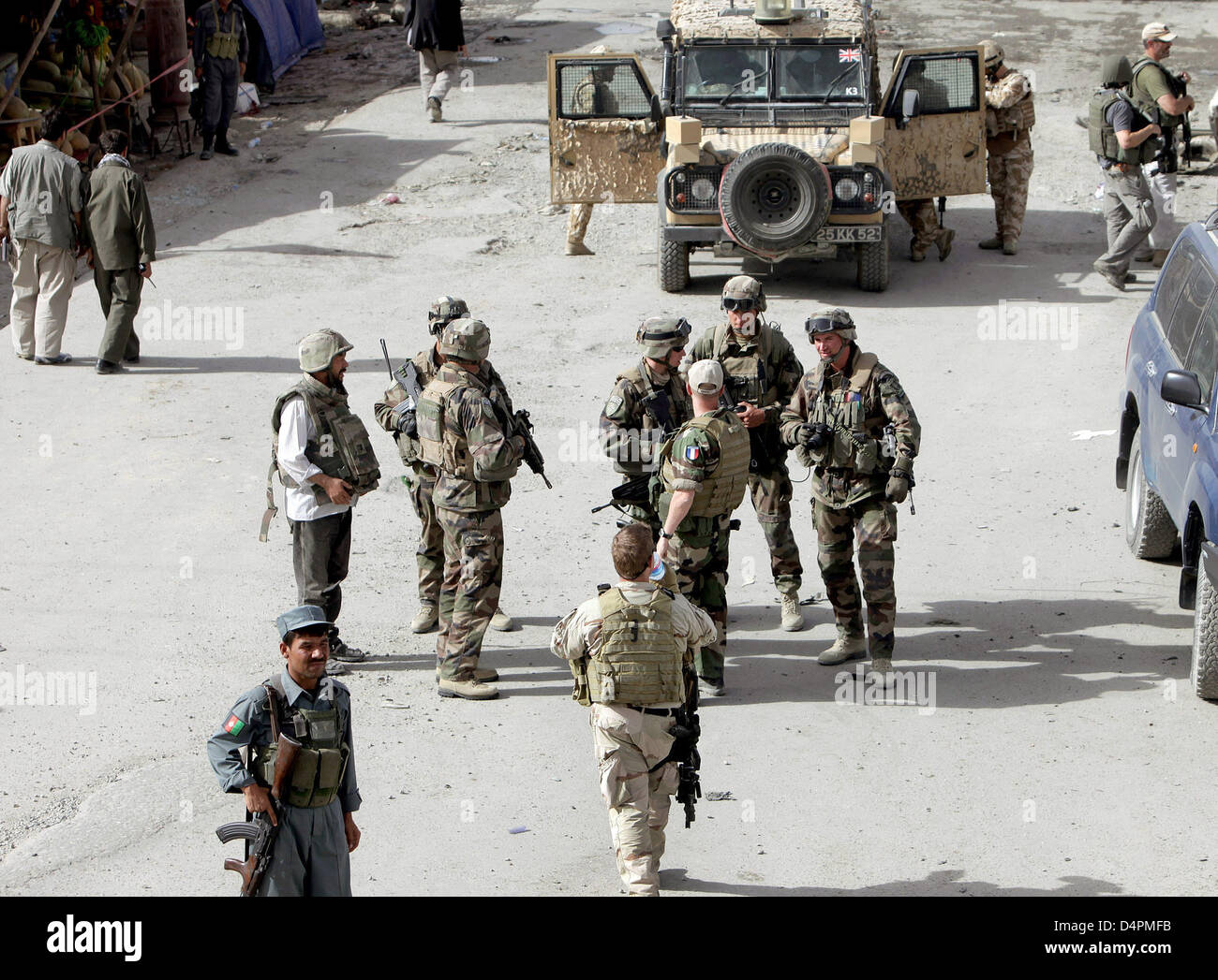 ISAF soldiers and Afghan police officers secure the scene of car bomb ...