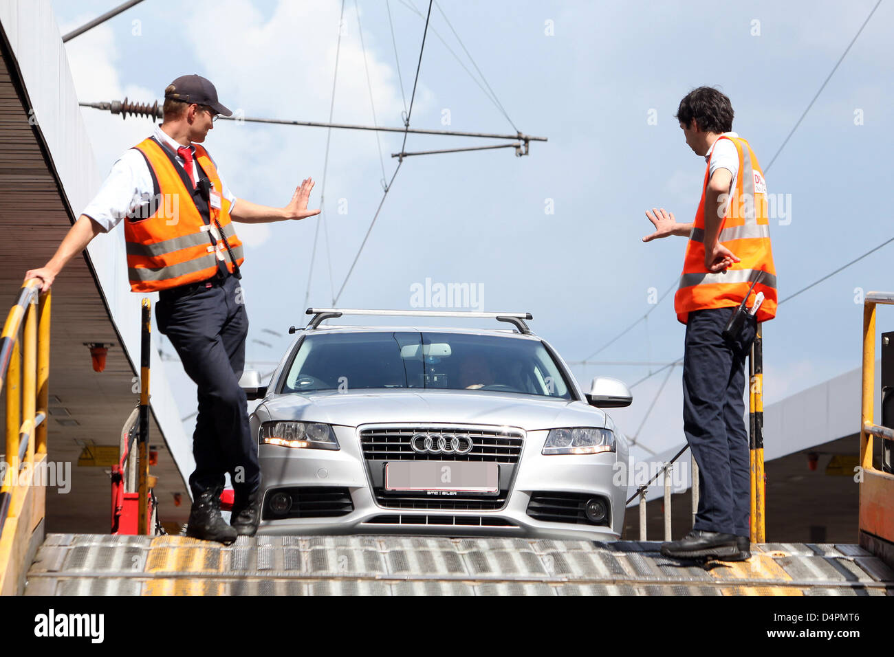 Railroad workers direct cars that leave a motorail train in Hamburg ...