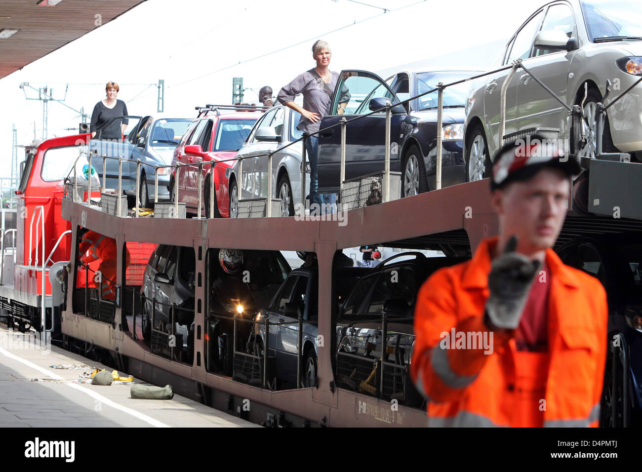 Passengers and railroad workers prepare to leave a motorail train in ...