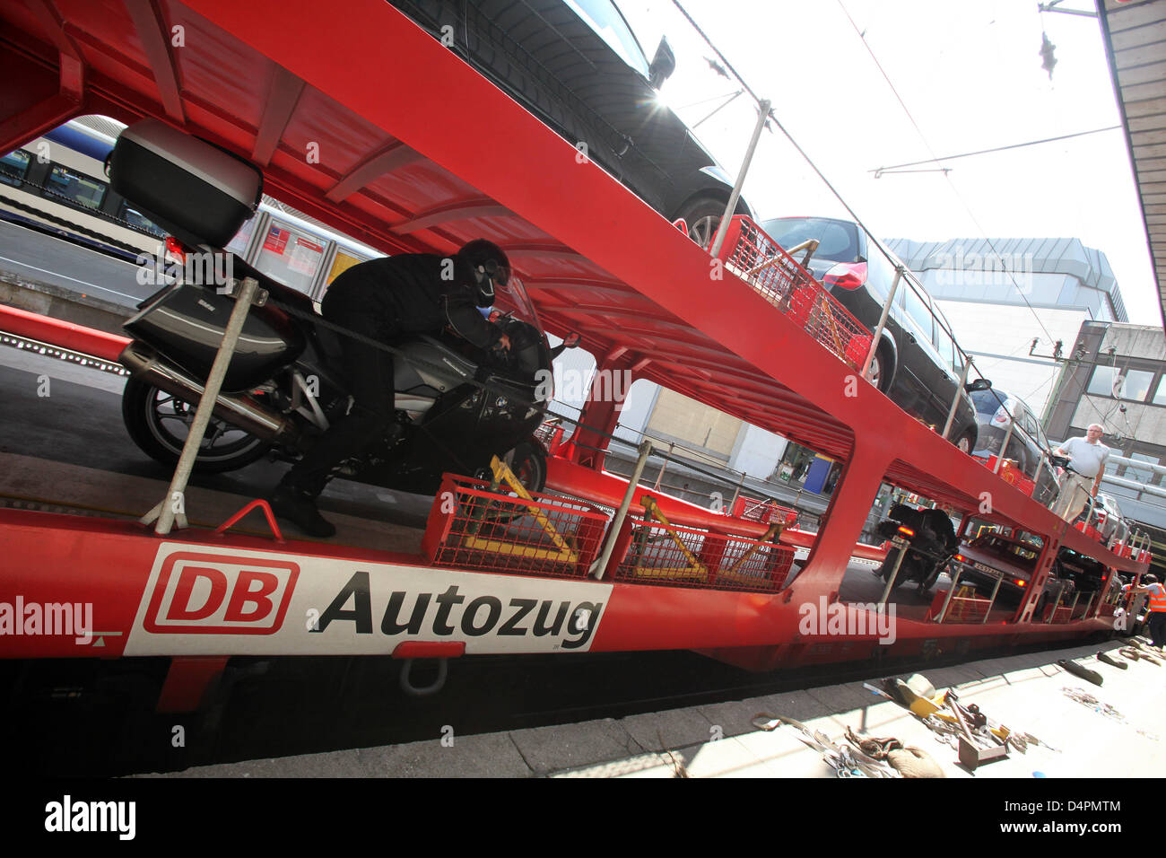 Passengers and railroad workers prepare to leave a motorail train in ...