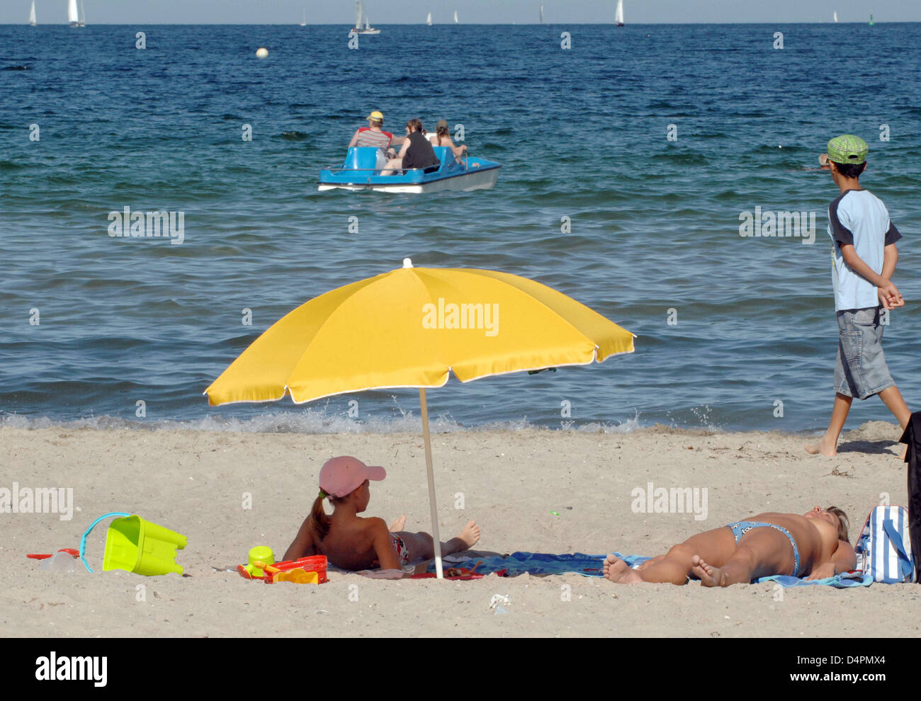 Vacationists sunbath on the Baltic Sea beach of Travemuende, Germany ...
