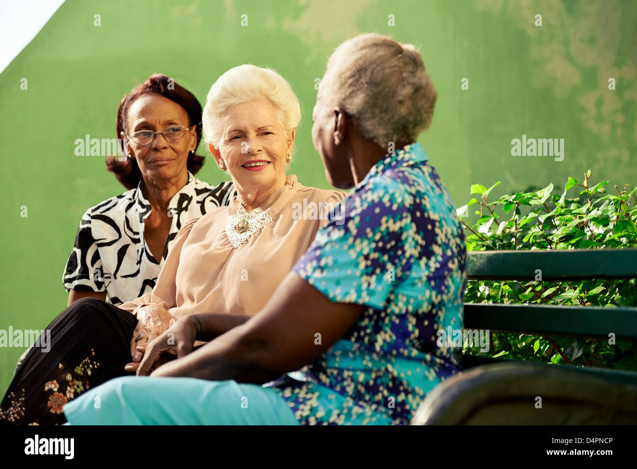 three old women sitting on bench in park and talking Stock Photo - Alamy