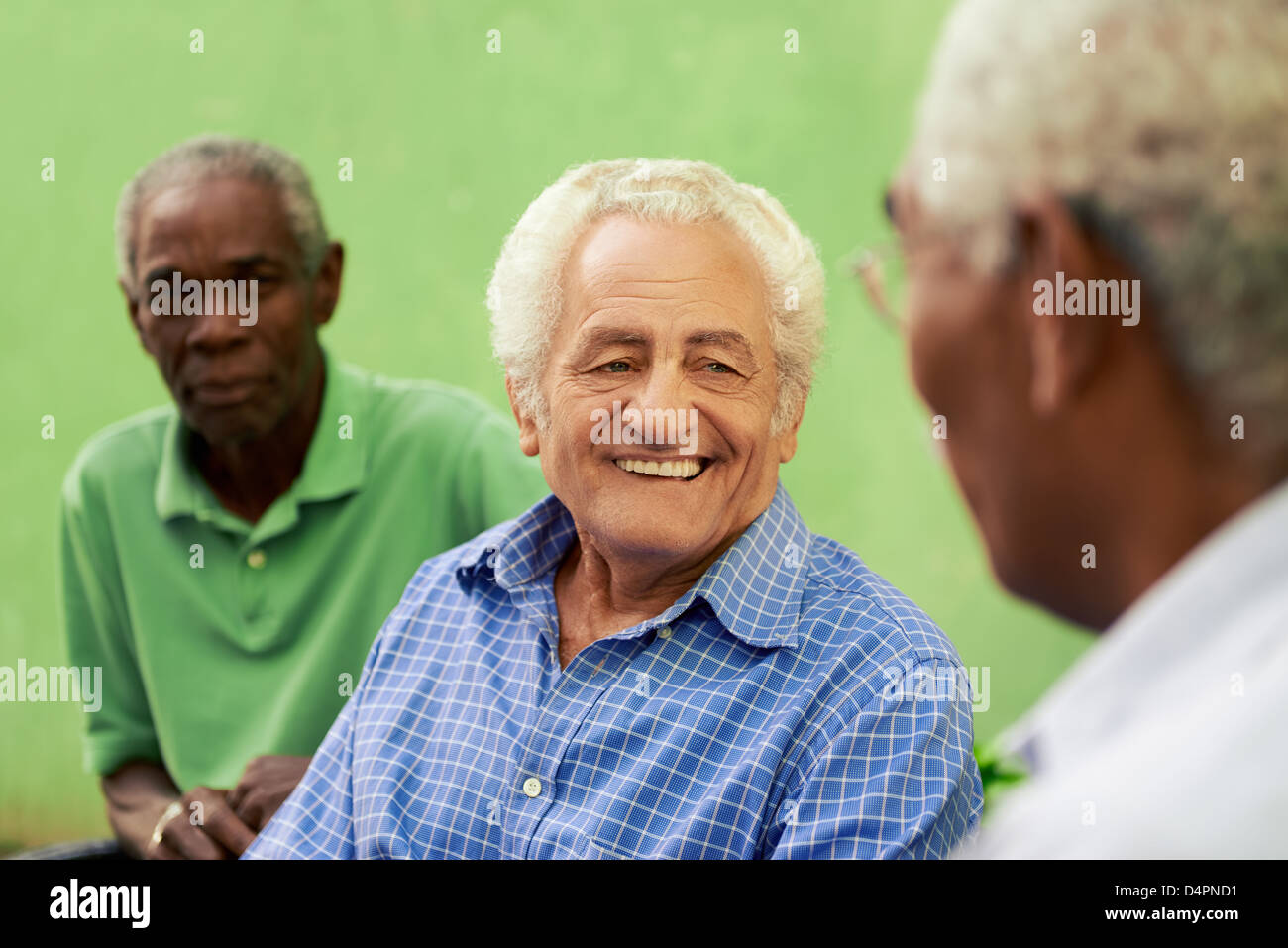 three senior men sitting on bench in park and talking Stock Photo - Alamy