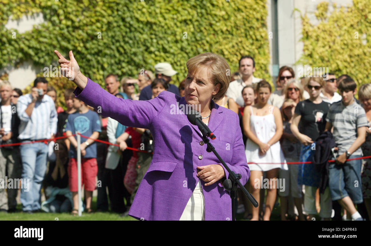 German Chancellor Angela Merkel shows visitors her office during the ...