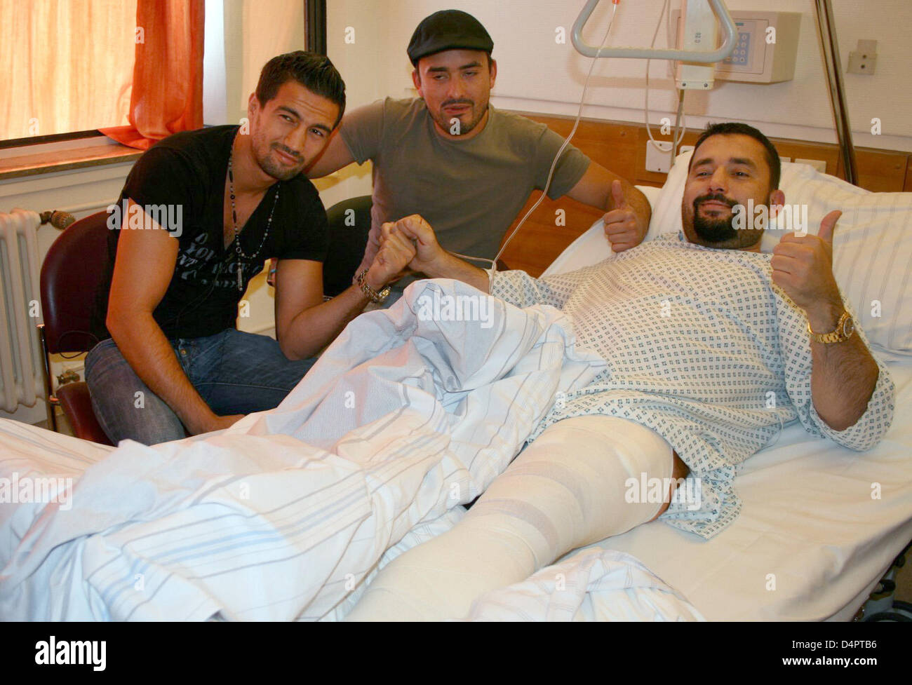 Turkish boxing manager Ahmet Oener (R) is visited by friends in a ...