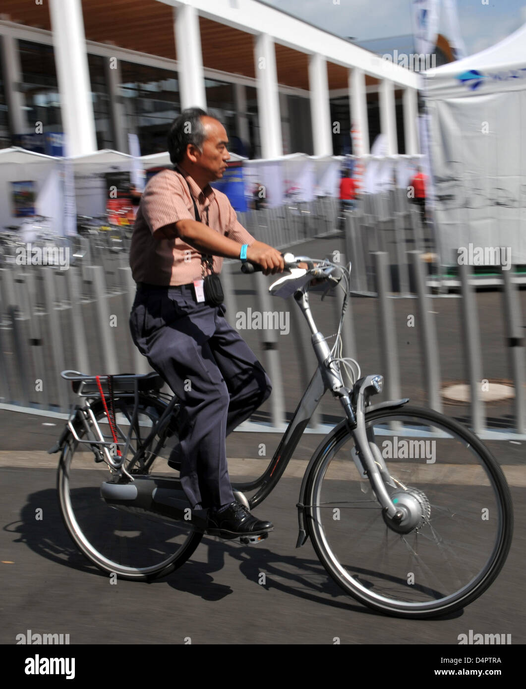 An Asian visitor on an Electro-bike at the international trade fair of ...
