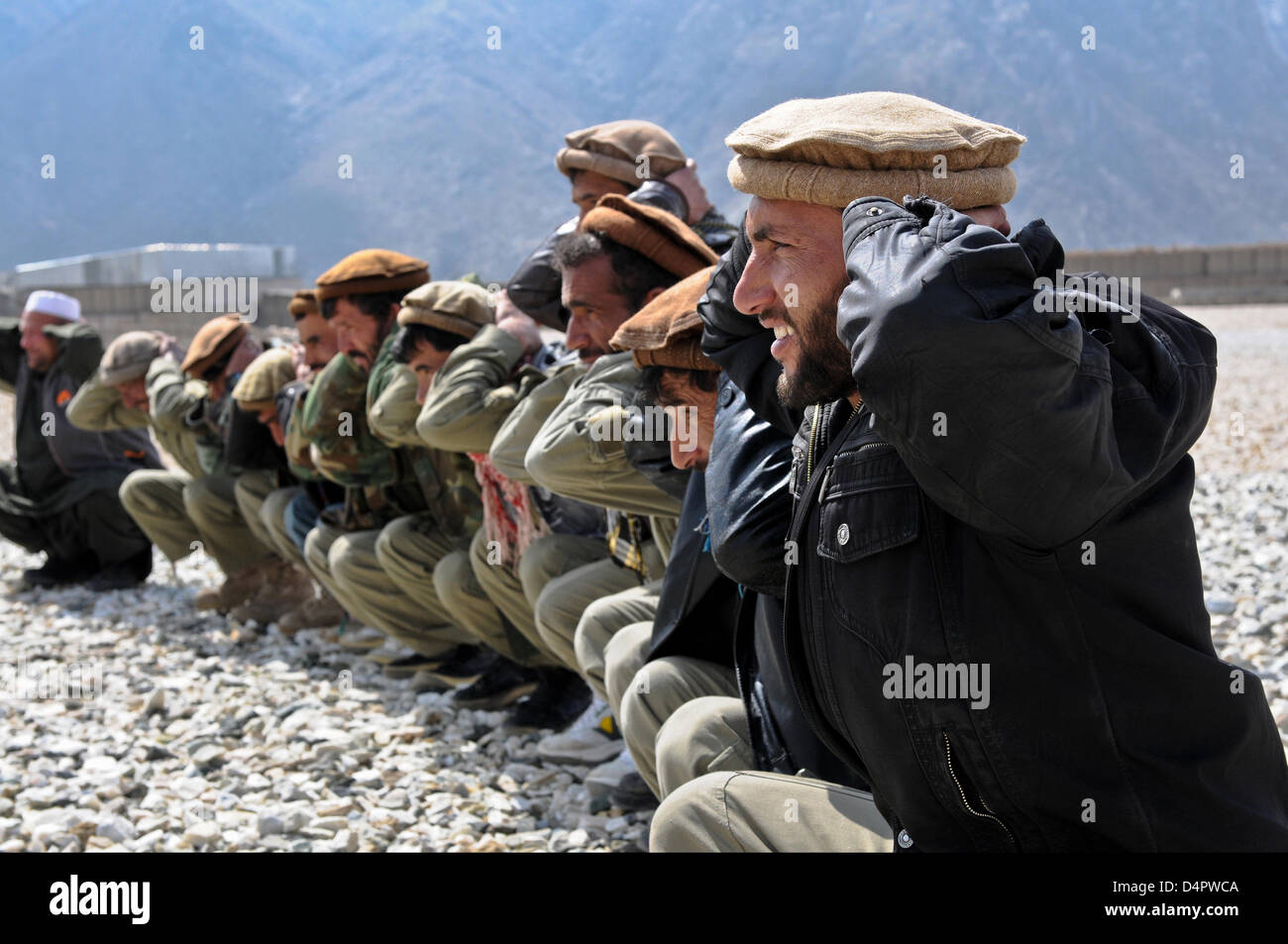 Afghan Local Police members dressed in traditional clothing squat ...